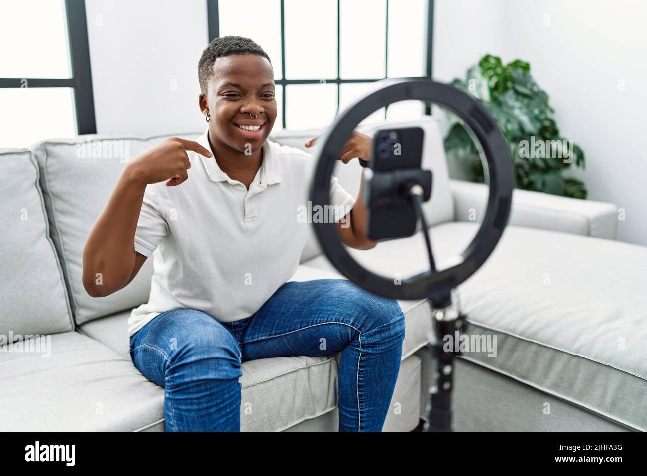 Young african man recording vlog tutorial with smartphone at home ...