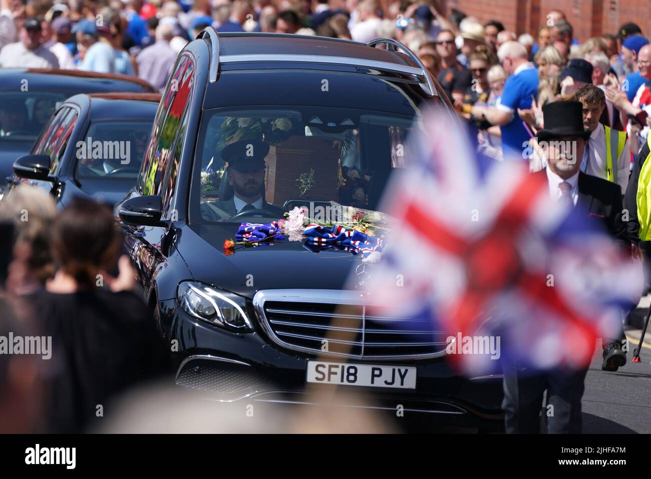 The crowd outside Ibrox Stadium watch the passing cortege ahead of the ...