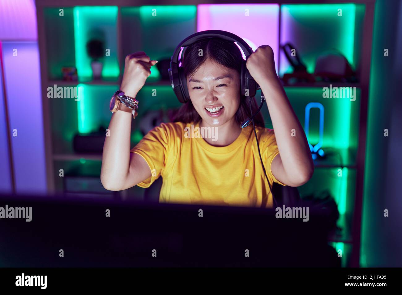 Chinese woman streamer using computer with winner expression at gaming ...