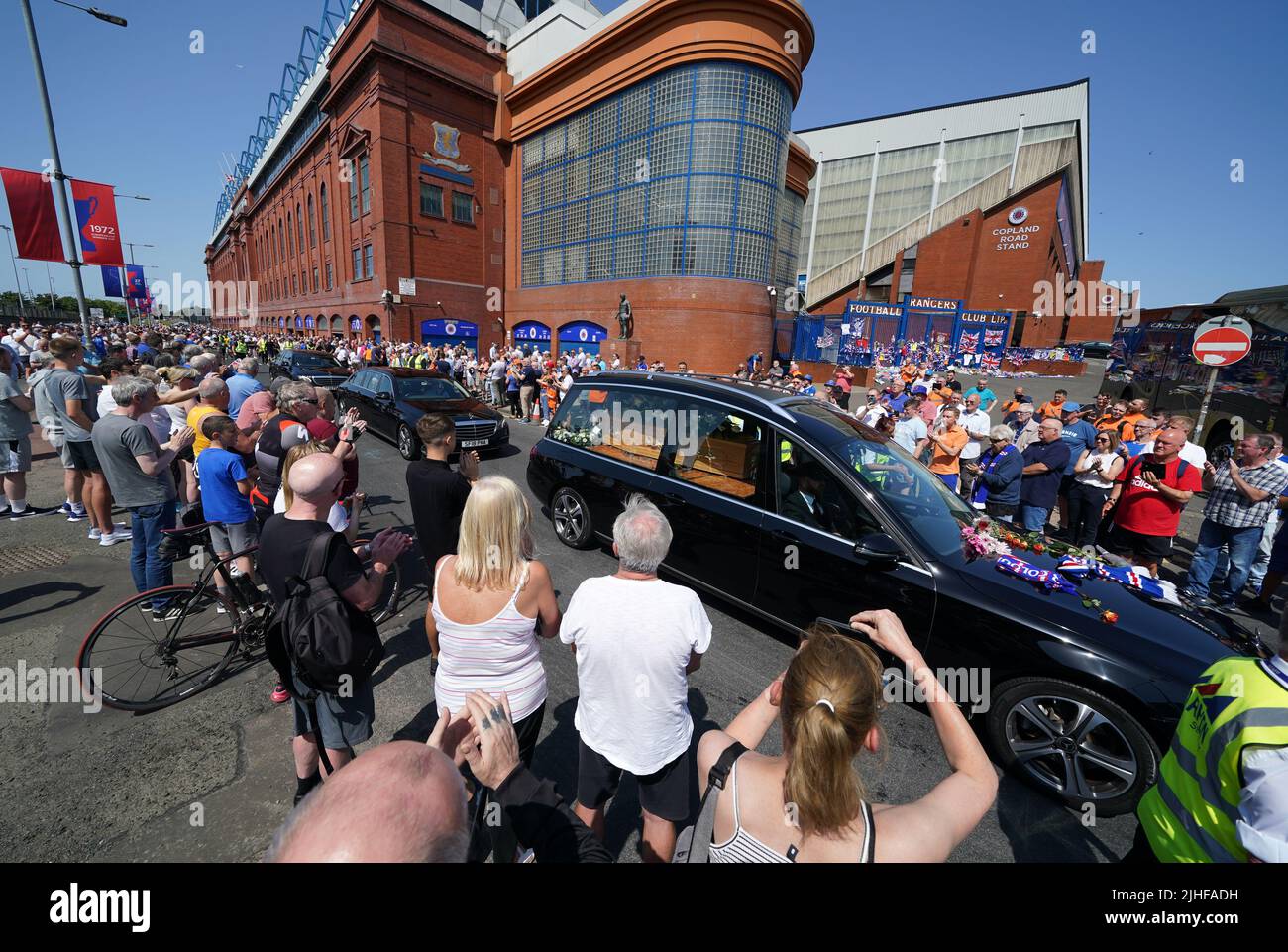 The crowd outside Ibrox Stadium watch the passing cortege ahead of the ...