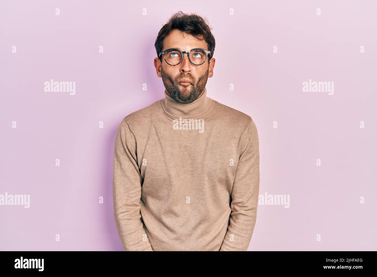 Handsome man with beard wearing turtleneck sweater and glasses making ...