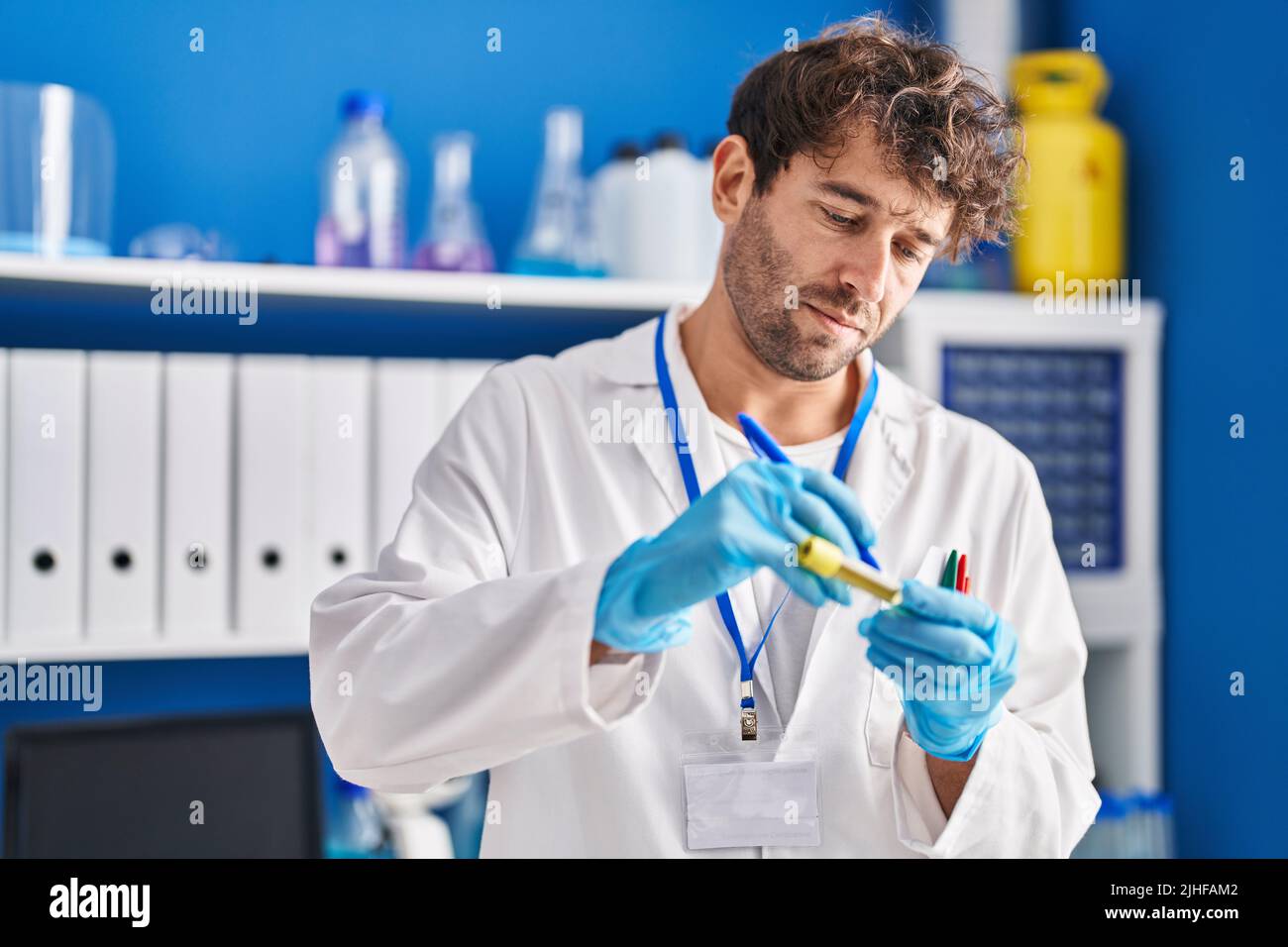 Young man scientist writing on test tube at laboratory Stock Photo - Alamy