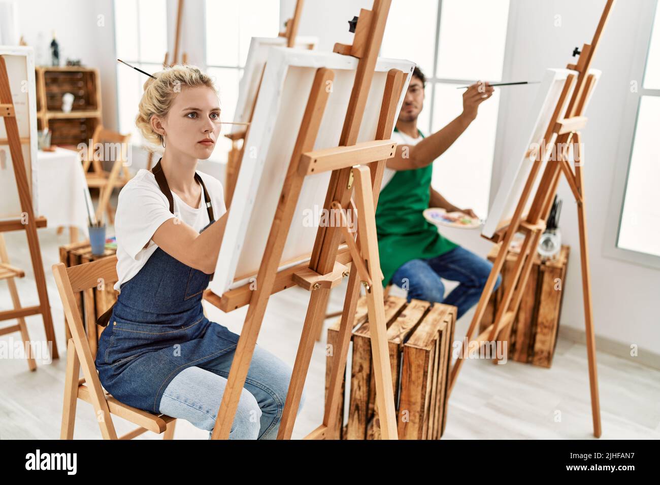 Young artist couple concentrated painting at art studio Stock Photo - Alamy