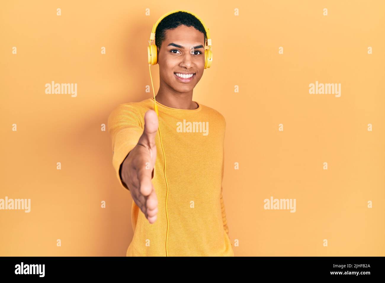 Young african american guy listening to music using headphones smiling ...
