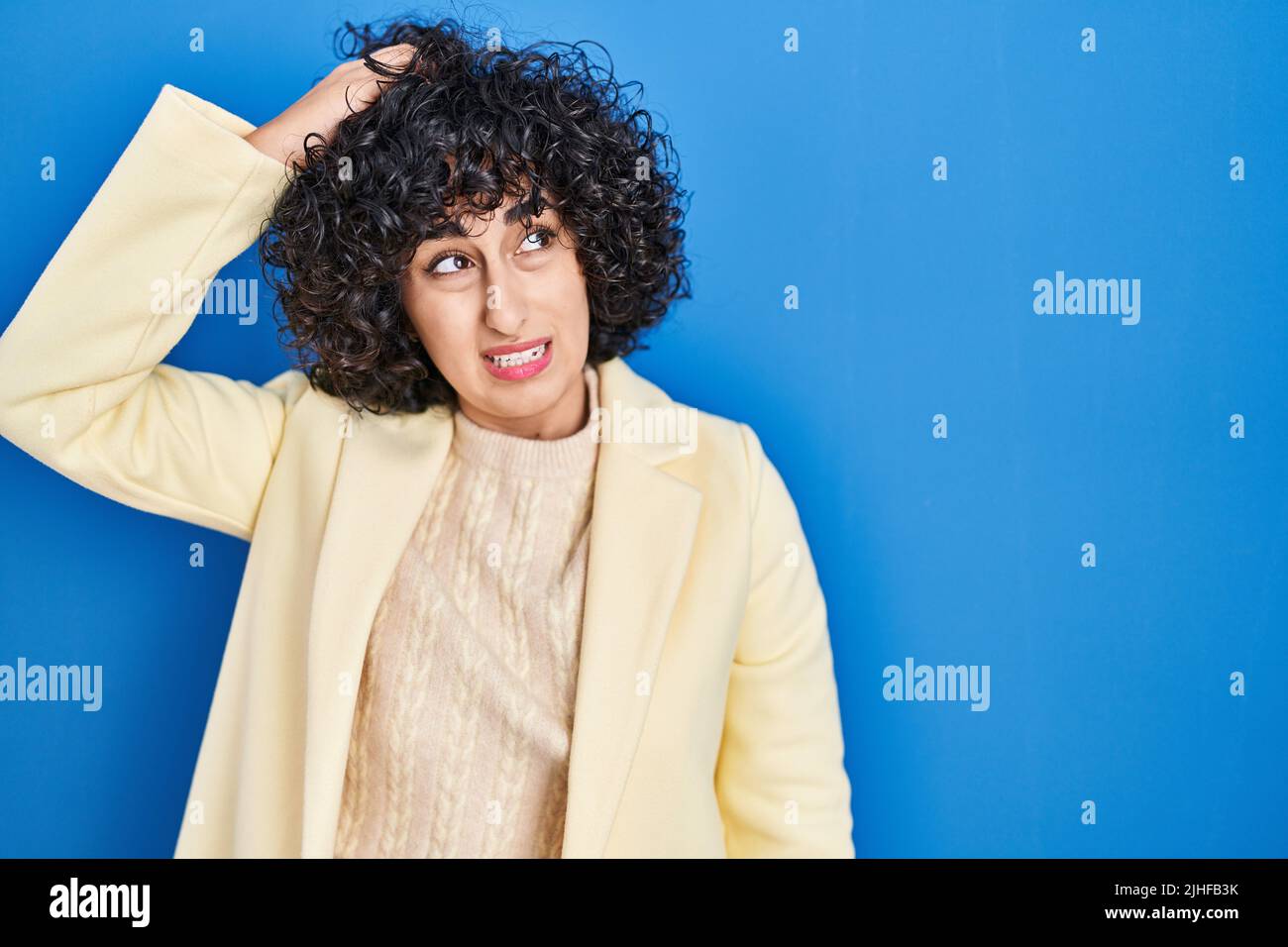 Young Brunette Woman With Curly Hair Standing Over Blue Background 5390