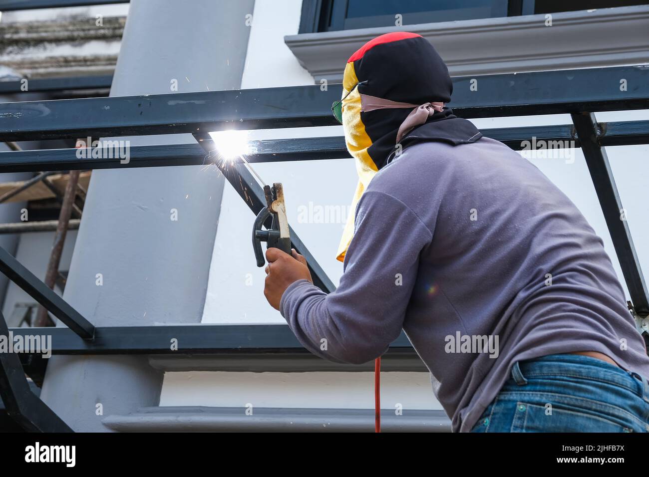 The welder is welding the steel structure to add to the house Stock ...