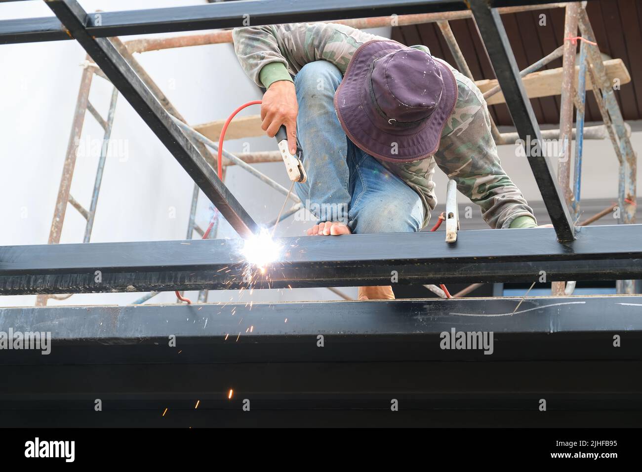 The welder is welding the steel structure to add to the house Stock ...