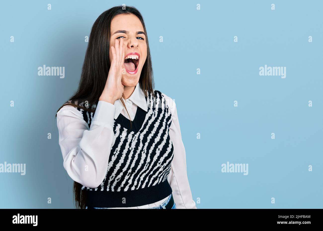 Young brunette teenager wearing casual elegant look shouting and ...