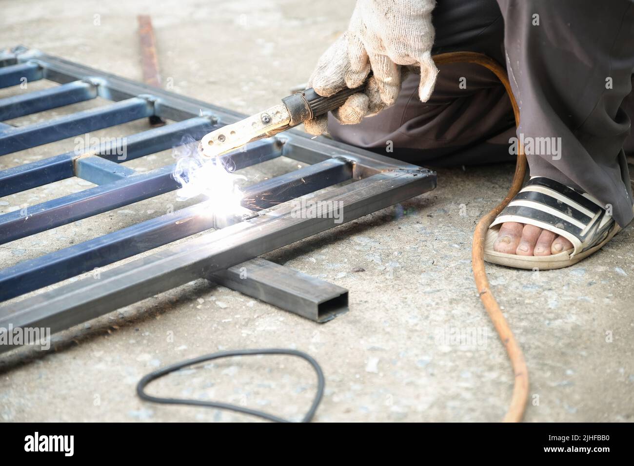 The welder is welding the steel structure to add to the house Stock ...