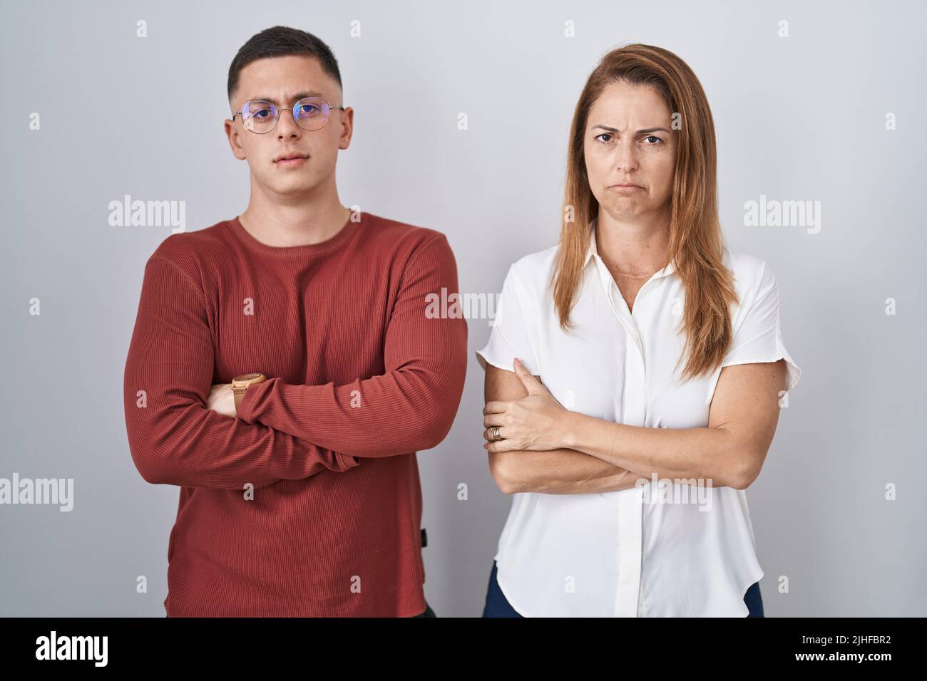 Mother and son standing together over isolated background skeptic and ...