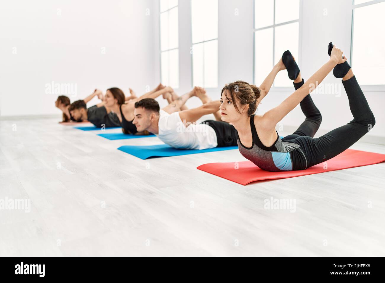 Group of young hispanic people concentrate training yoga at sport ...