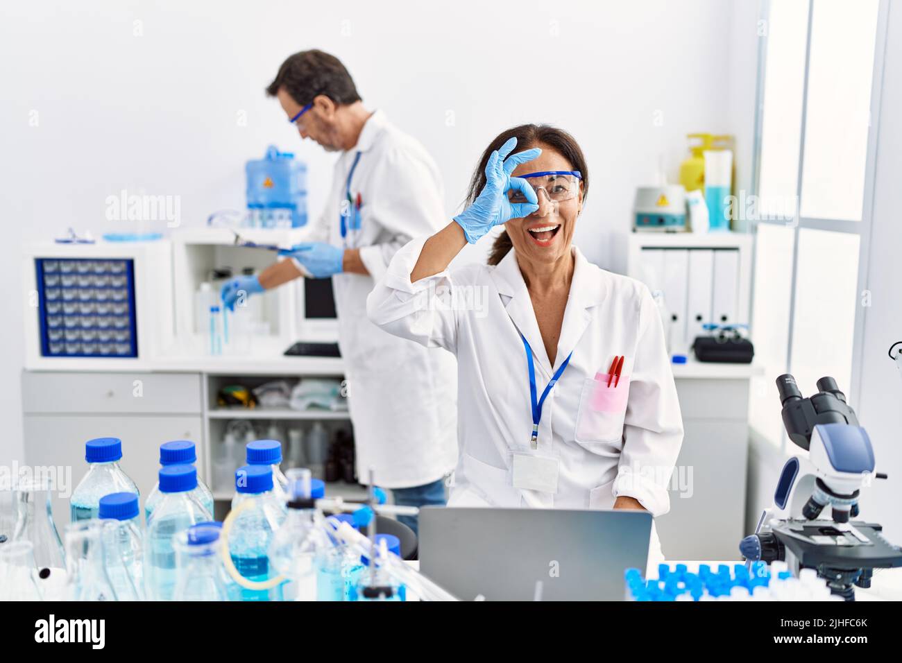 Middle age woman working at scientist laboratory smiling happy doing ok ...