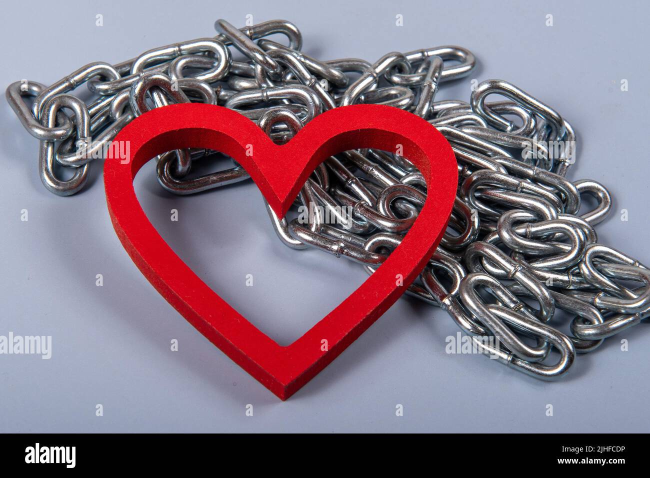 Heart shape with metallic chain around it in a blue background Stock ...