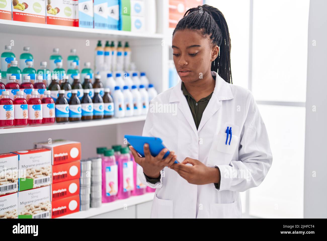 African american woman pharmacist using touchpad working at pharmacy ...