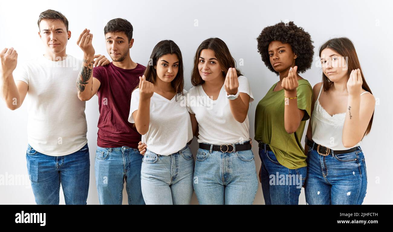Group of young friends standing together over isolated background doing ...