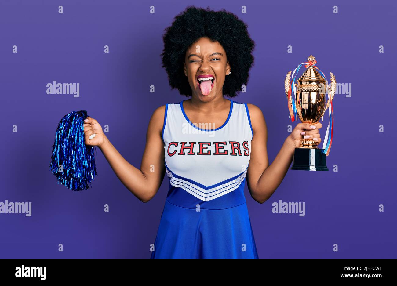 Young african american woman wearing cheerleader uniform holding pompom ...