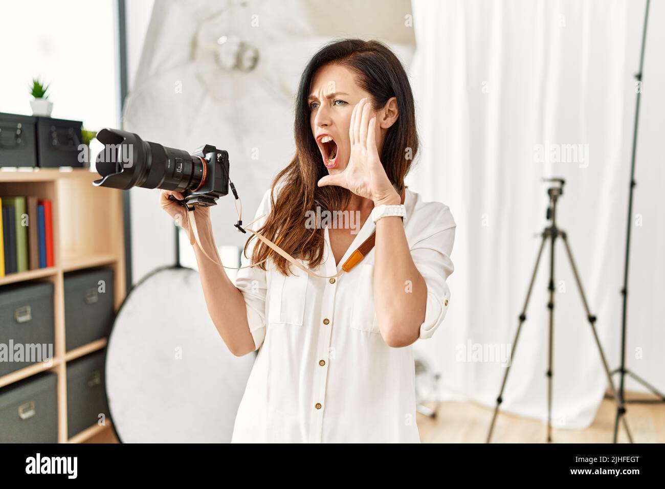 Beautiful caucasian woman working as photographer at photography studio ...
