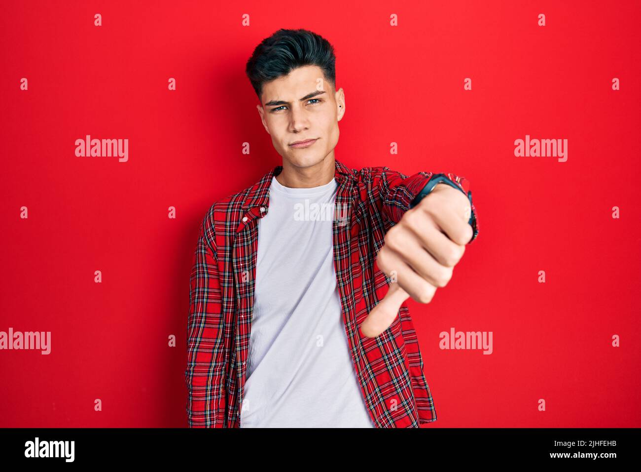 Young hispanic man wearing casual clothes looking unhappy and angry ...