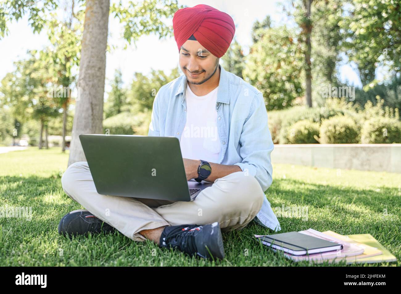 Serene Indian male student in traditional turban using laptop for ...