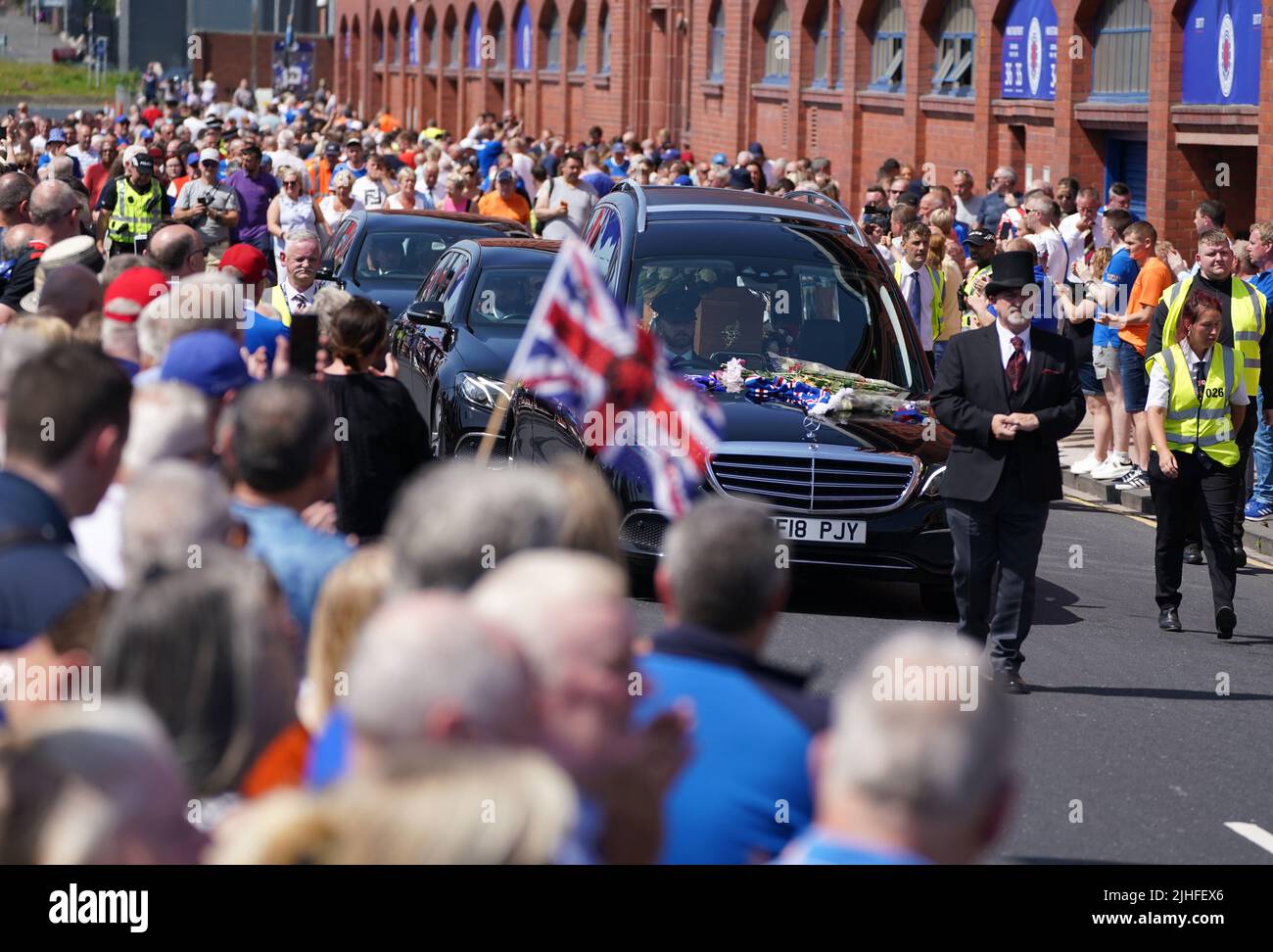 The crowd outside Ibrox Stadium watch the passing cortege ahead of the ...