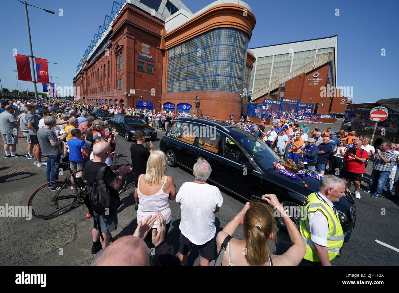 The crowd outside Ibrox Stadium watch the passing cortege ahead of the ...