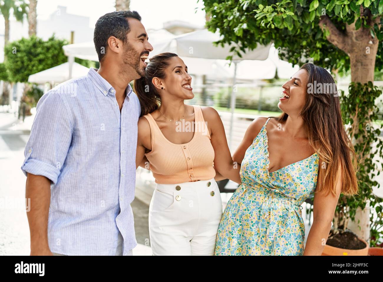 Three hispanic friends smiling happy and hugging at the city Stock ...