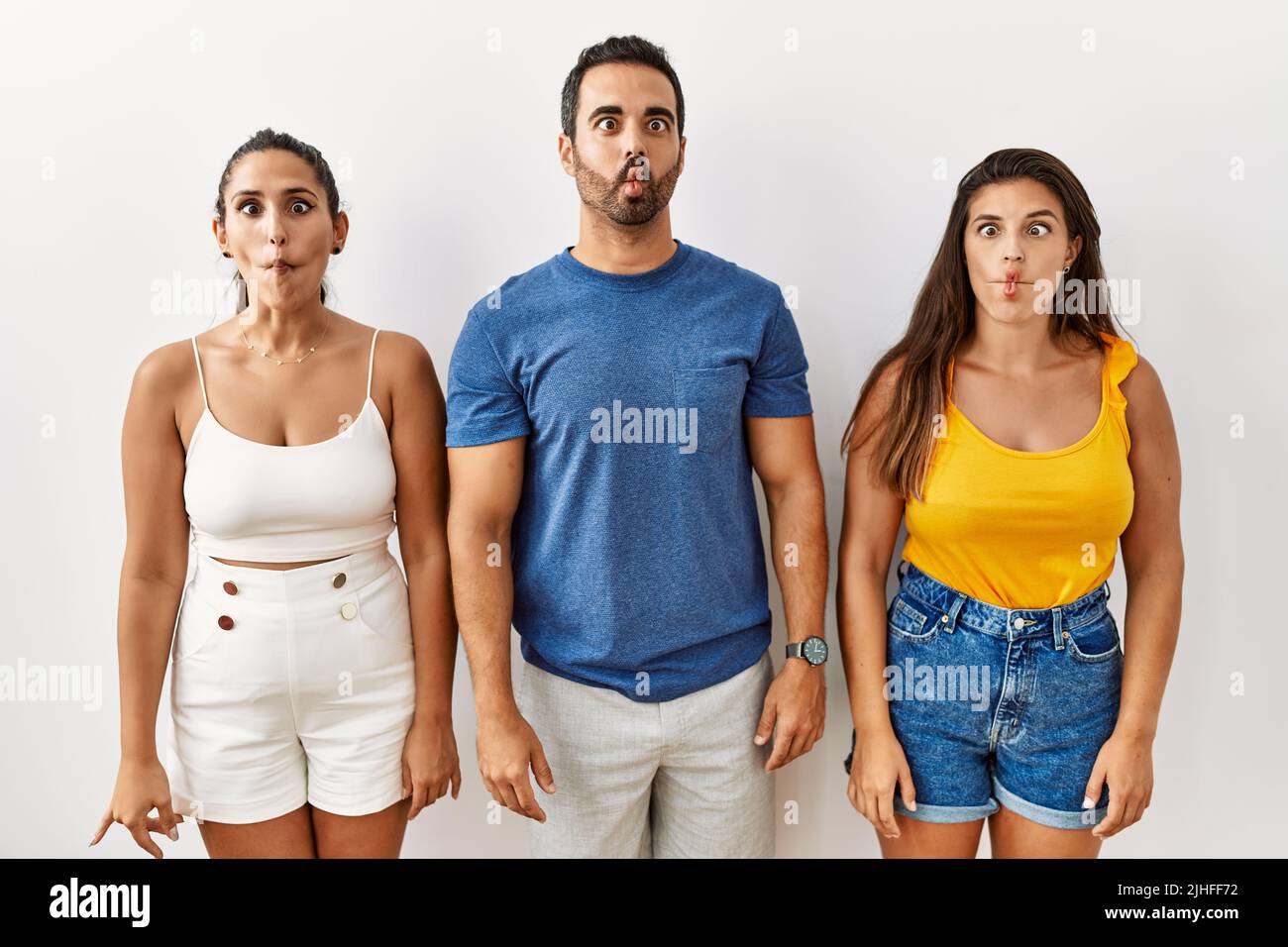 Group of young hispanic people standing over isolated background making ...