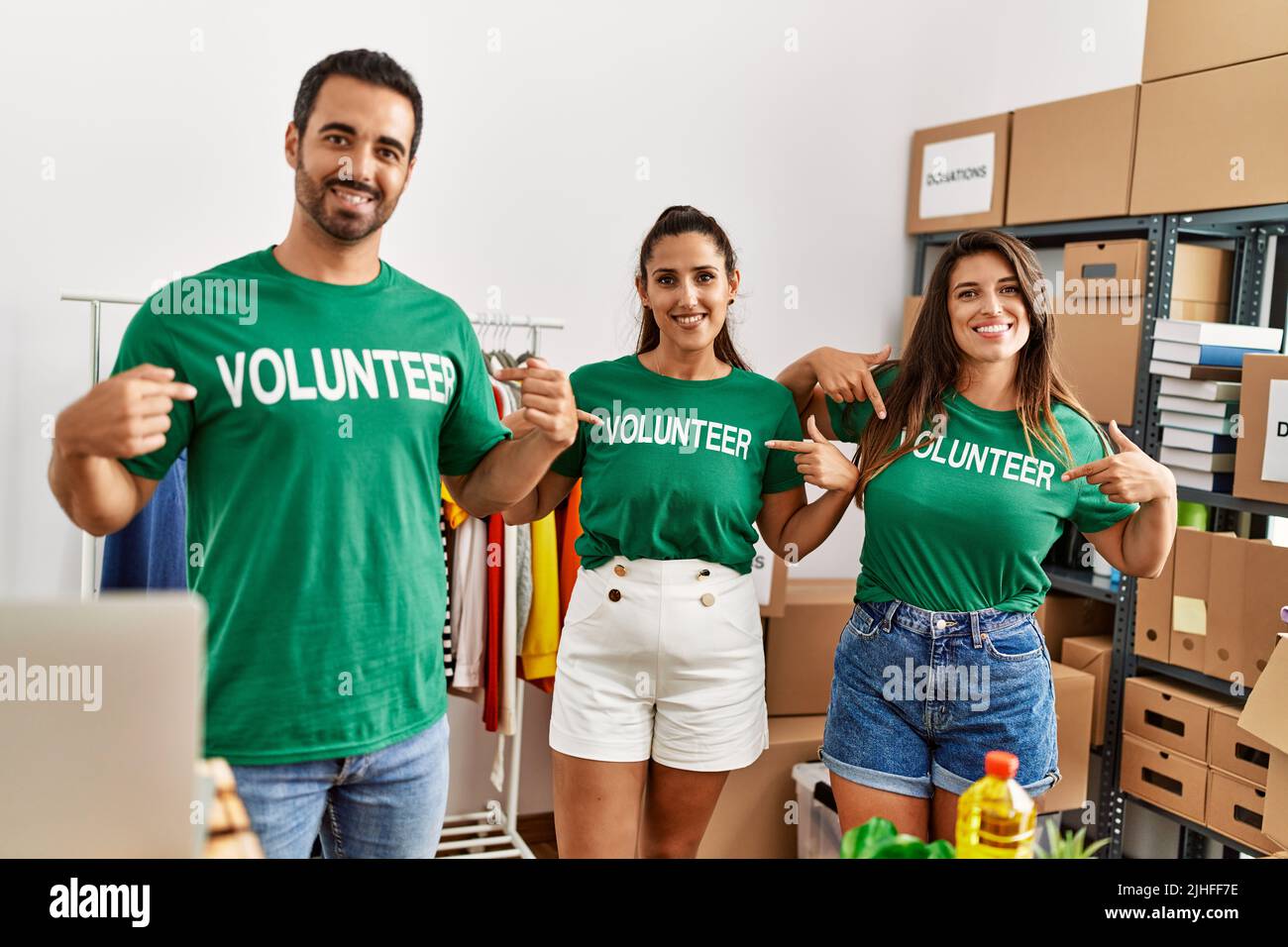 Group of hispanic volunteers smiling happy pointing with fingers to ...