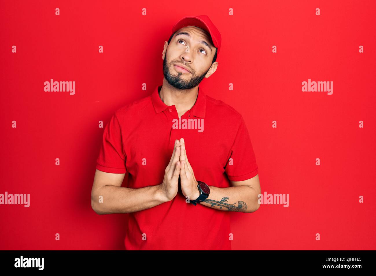 Hispanic Man With Beard Wearing Delivery Uniform And Cap Begging And