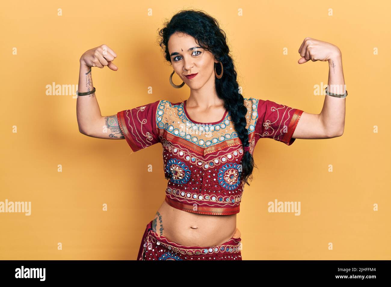 Young woman wearing bindi and bollywood clothing showing arms muscles ...