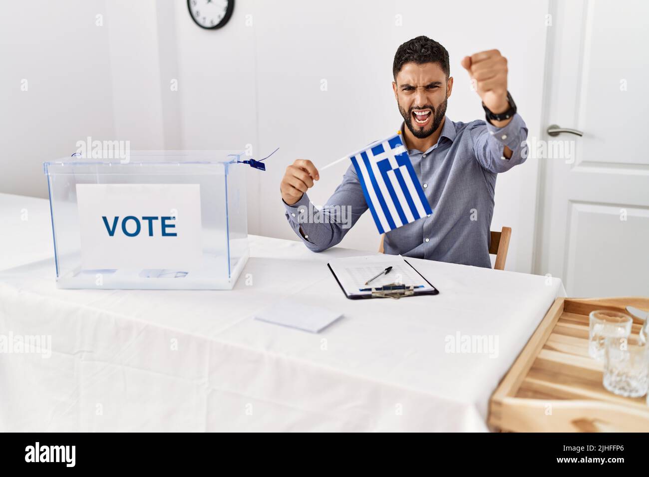 Young handsome man with beard at political campaign election holding ...