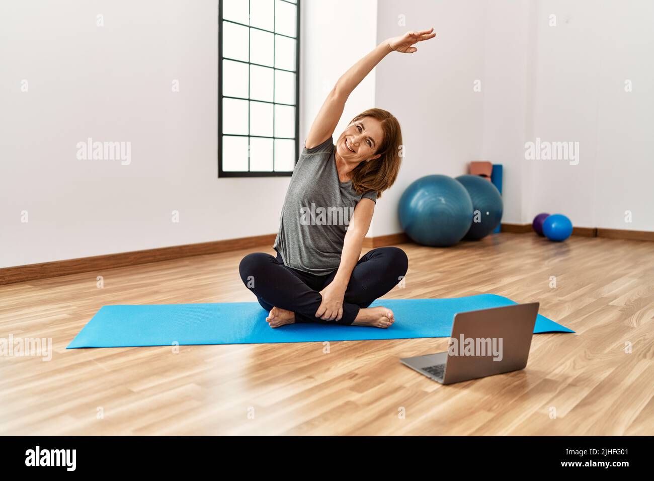 Middle age caucasian woman smiling confident having online yoga class ...