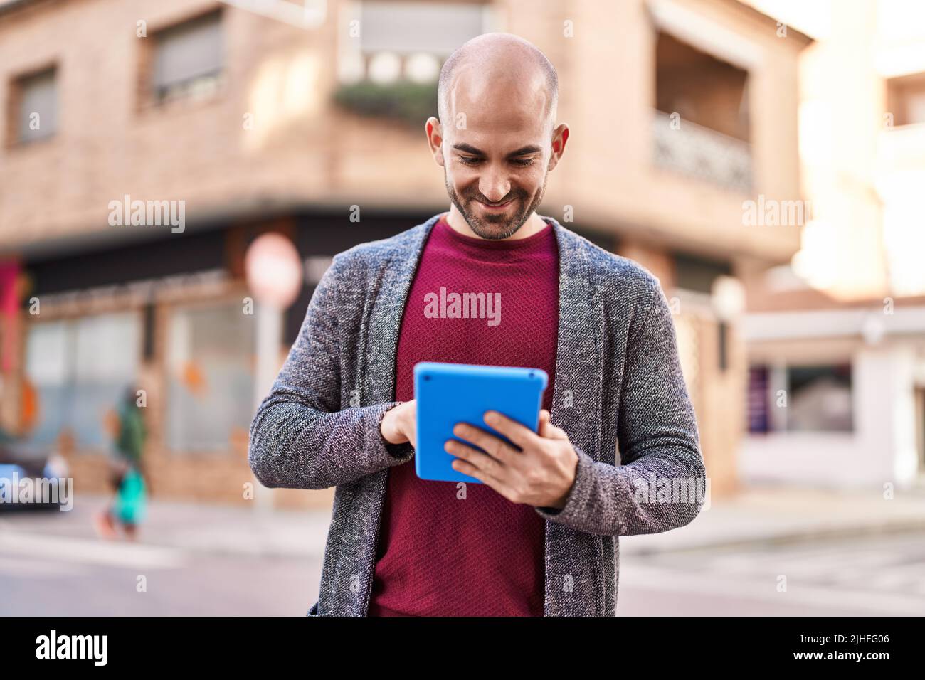 Young man smiling confident using touchpad at street Stock Photo - Alamy