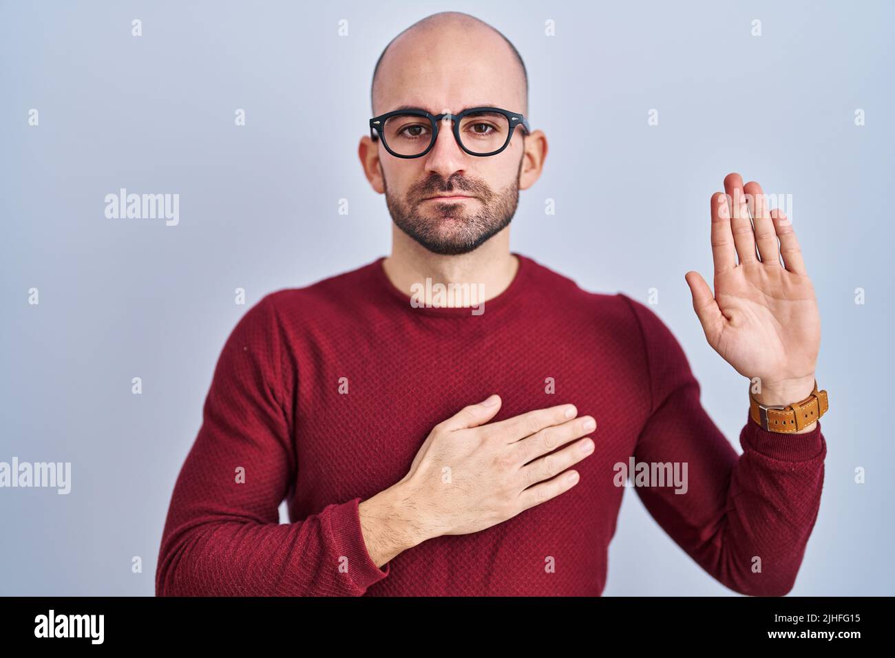 Young bald man with beard standing over white background wearing ...