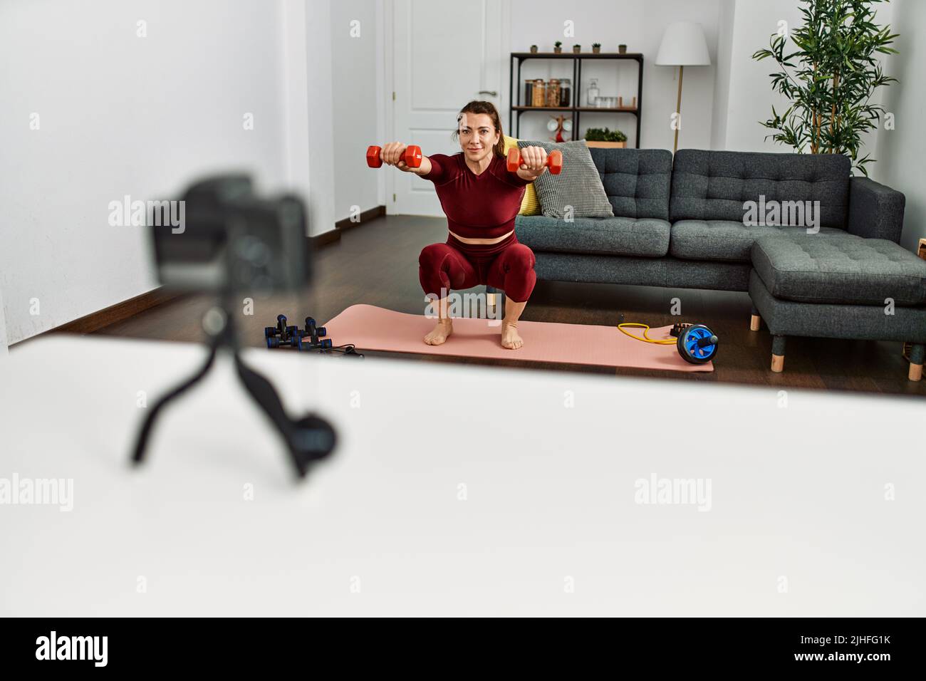 Middle age caucasian sporty woman doing training tutorial using camera ...