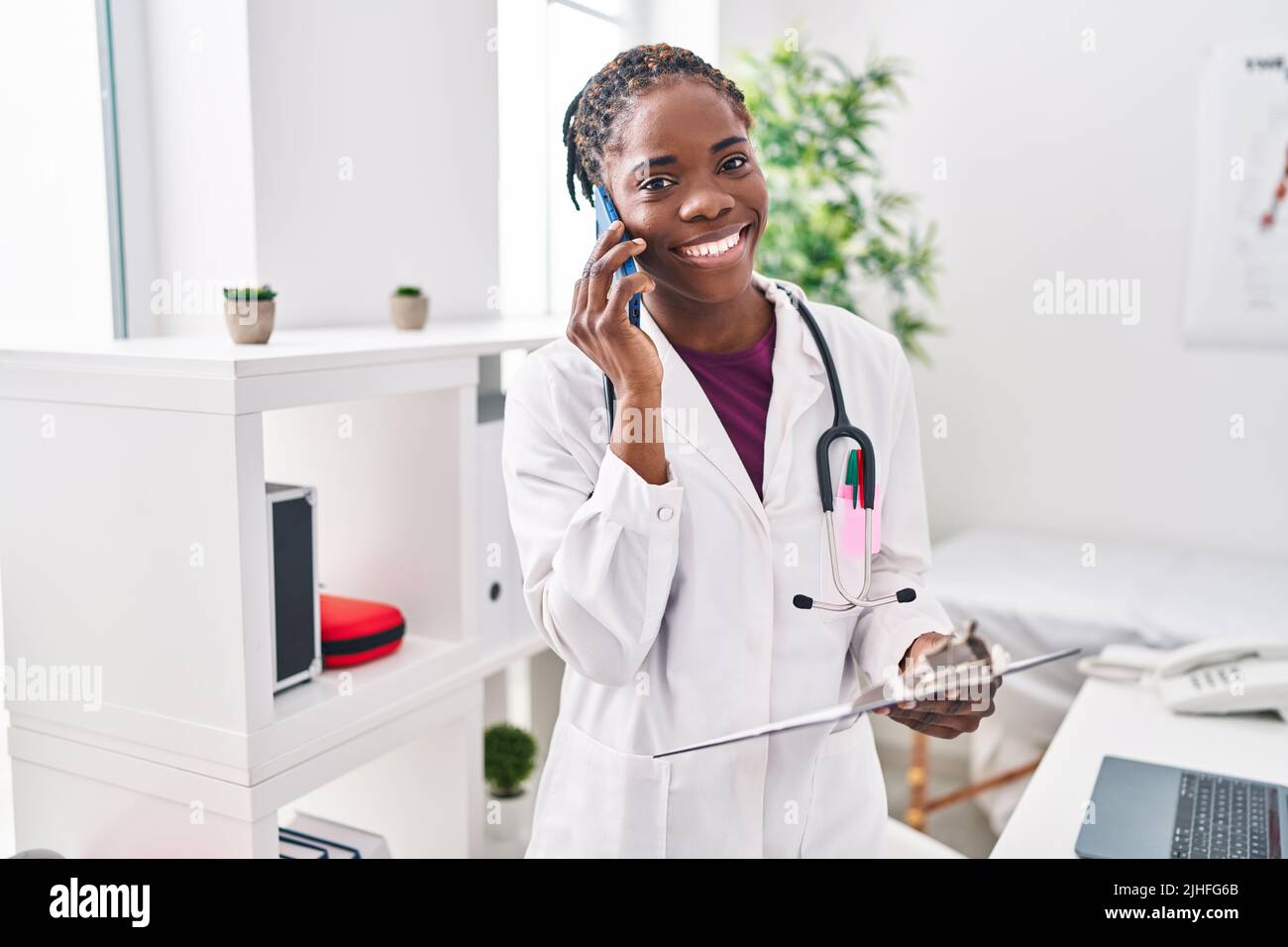 African american woman wearing doctor uniform talking on the smartphone ...