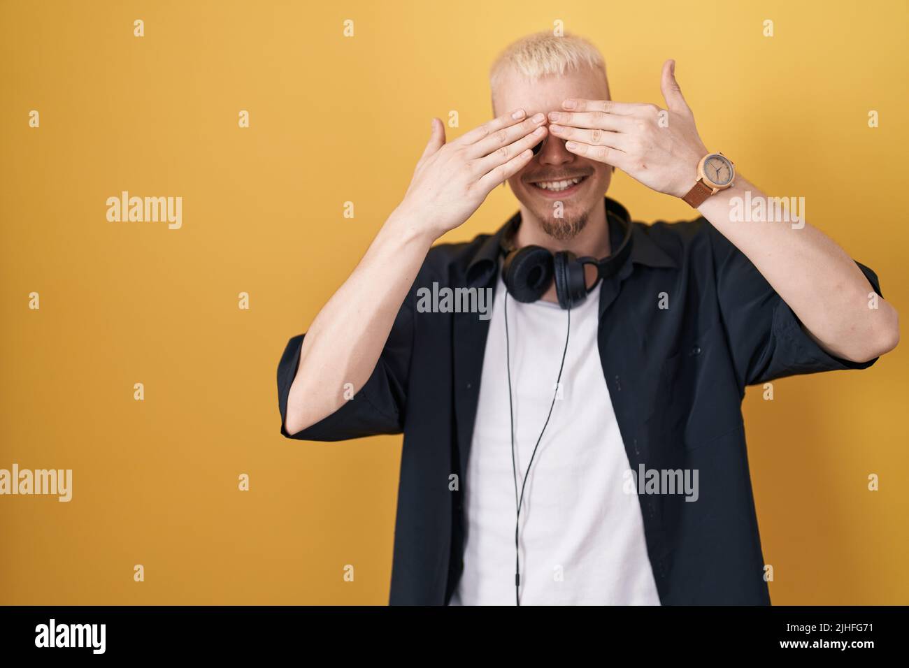 Young caucasian man wearing sunglasses standing over yellow background ...