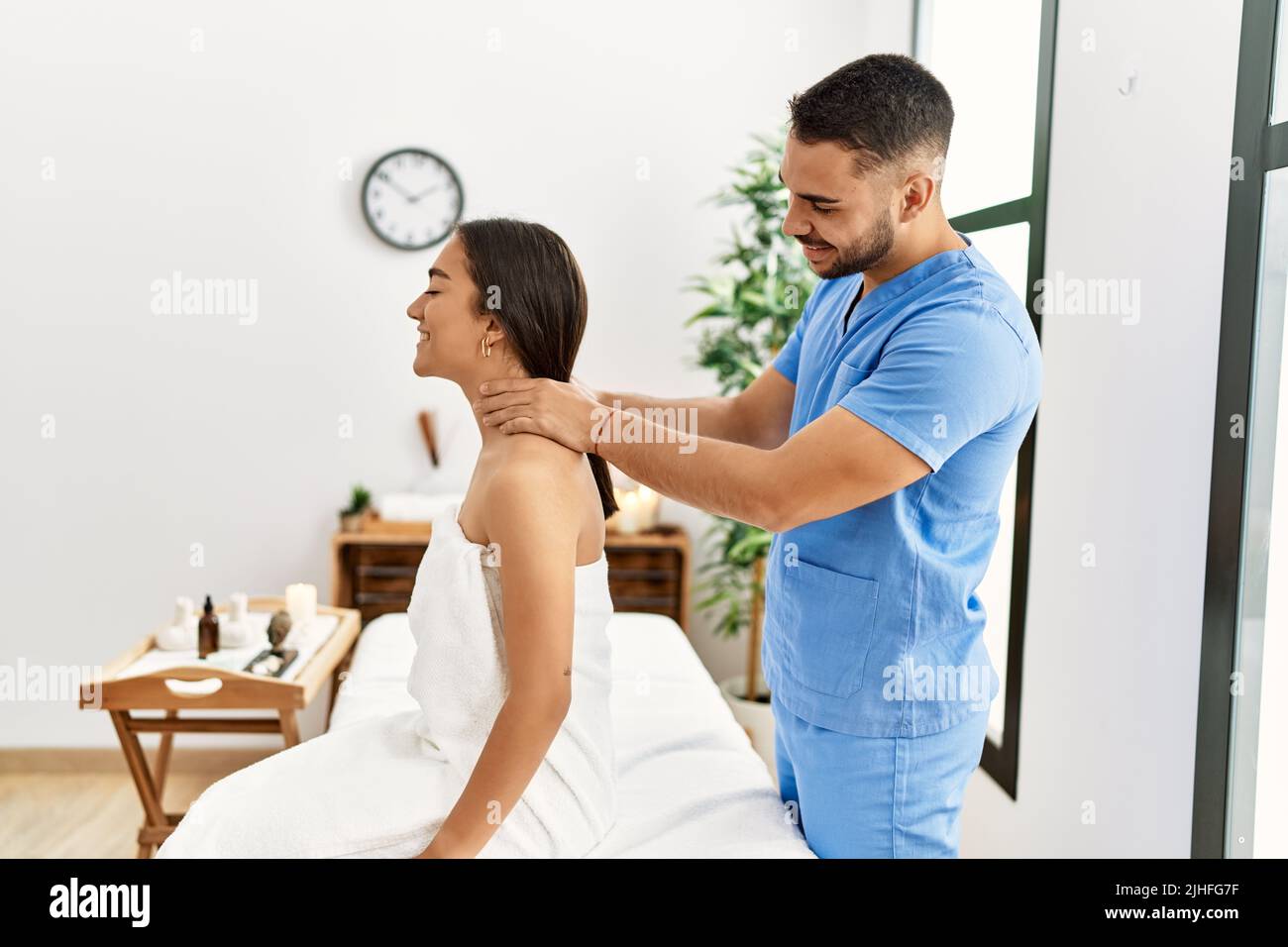 Latin man and woman wearing physiotherapy uniform having rehab session ...