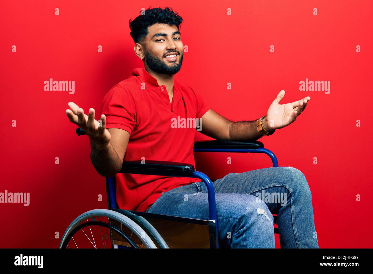 Arab man with beard sitting on wheelchair smiling showing both hands ...