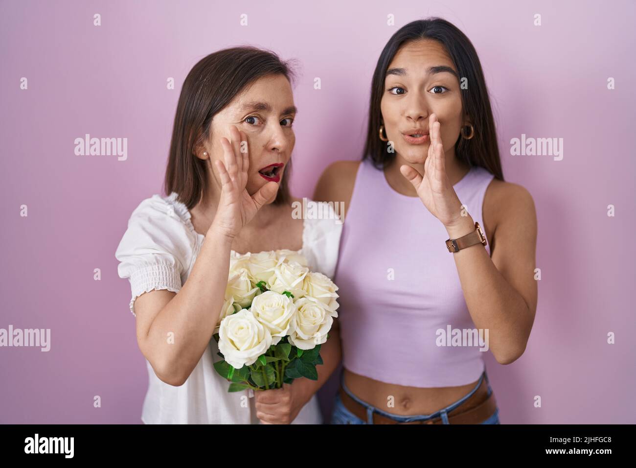 Hispanic mother and daughter holding bouquet of white flowers hand on ...