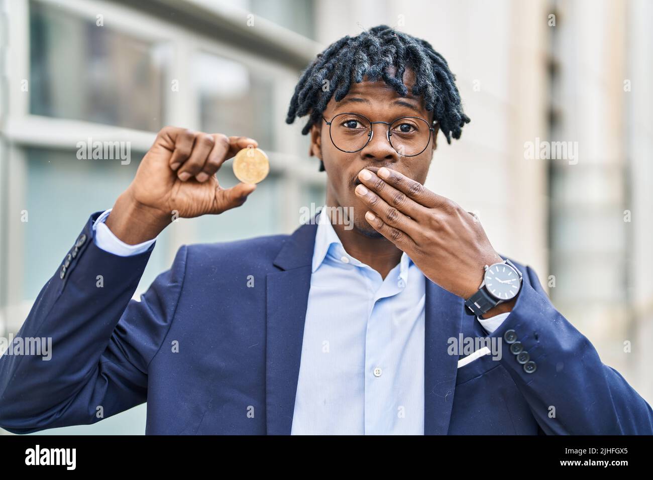 Young african man with dreadlocks holding virtual currency bitcoin ...