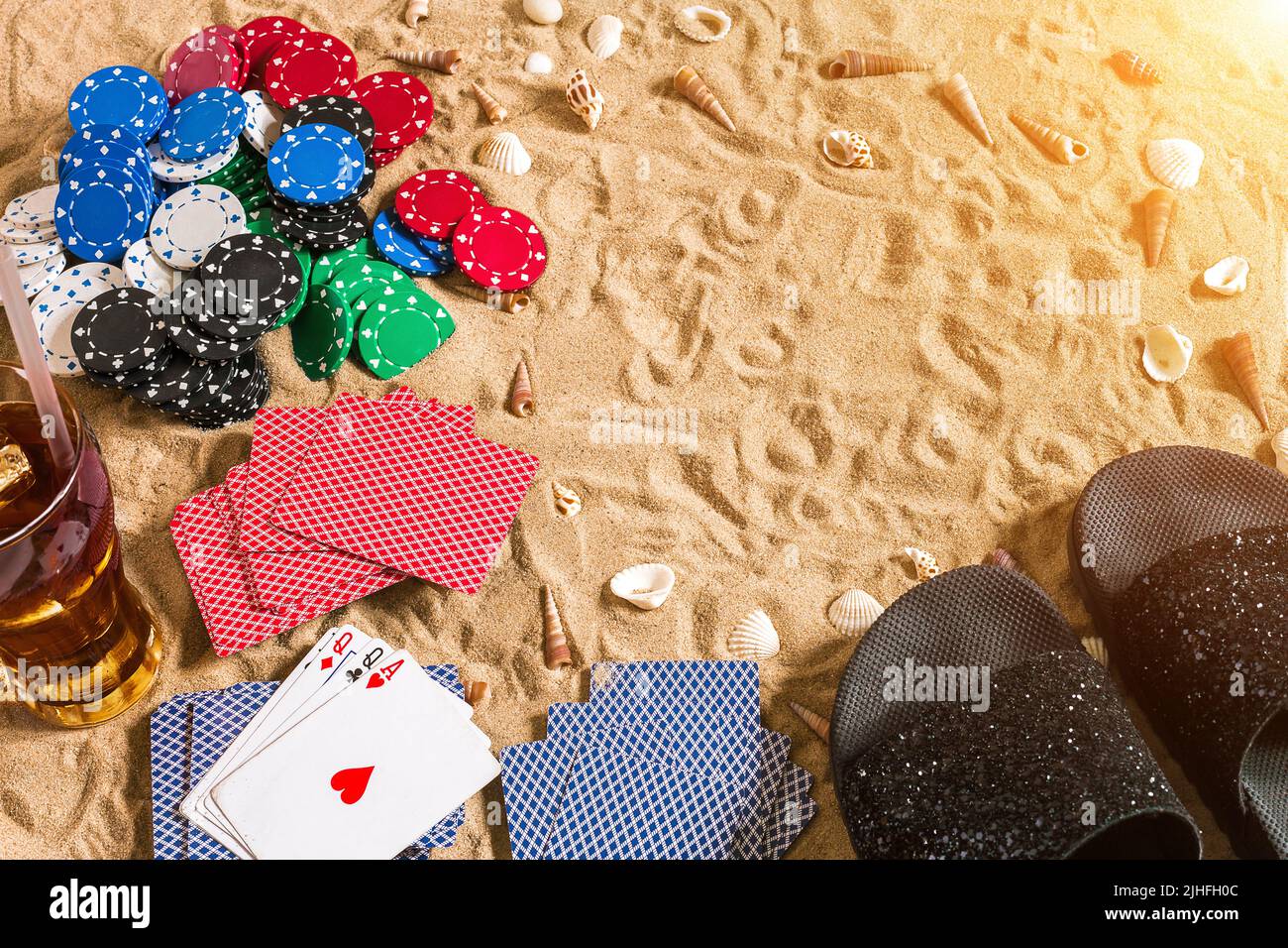 Beachpoker. Chips and cards on the sand. Around the seashells ...
