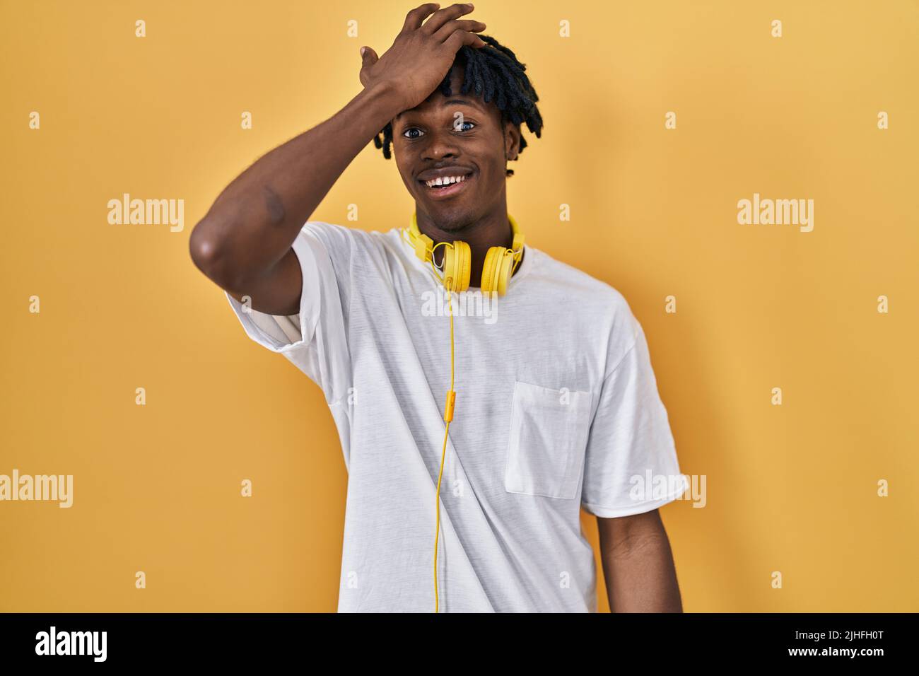 Young african man with dreadlocks standing over yellow background ...