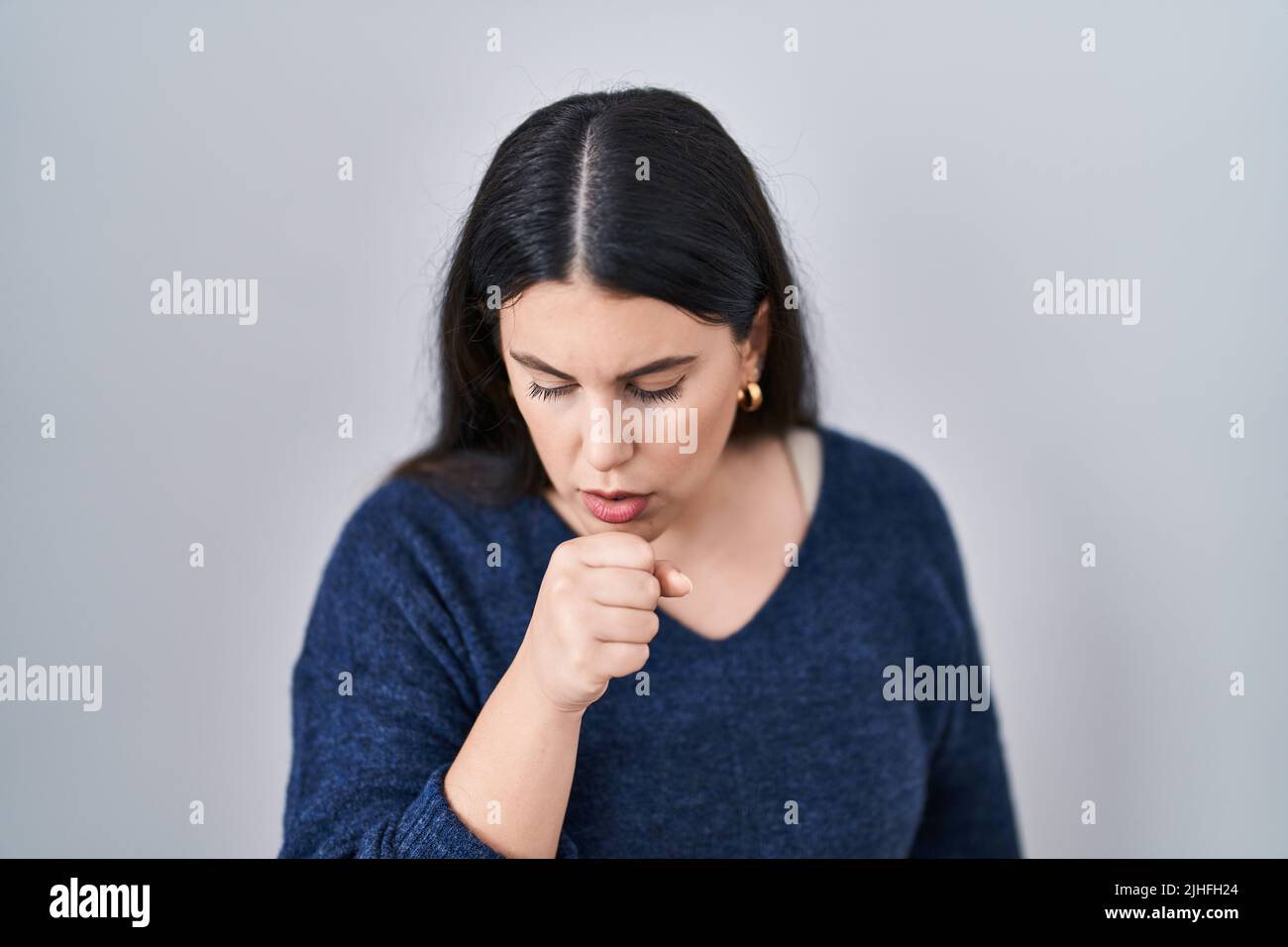 Young brunette woman standing over isolated background feeling unwell ...