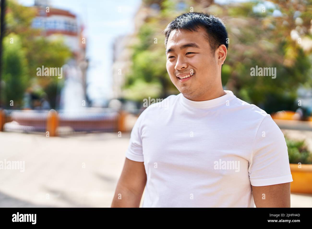 Young chinese man smiling confident standing at park Stock Photo - Alamy