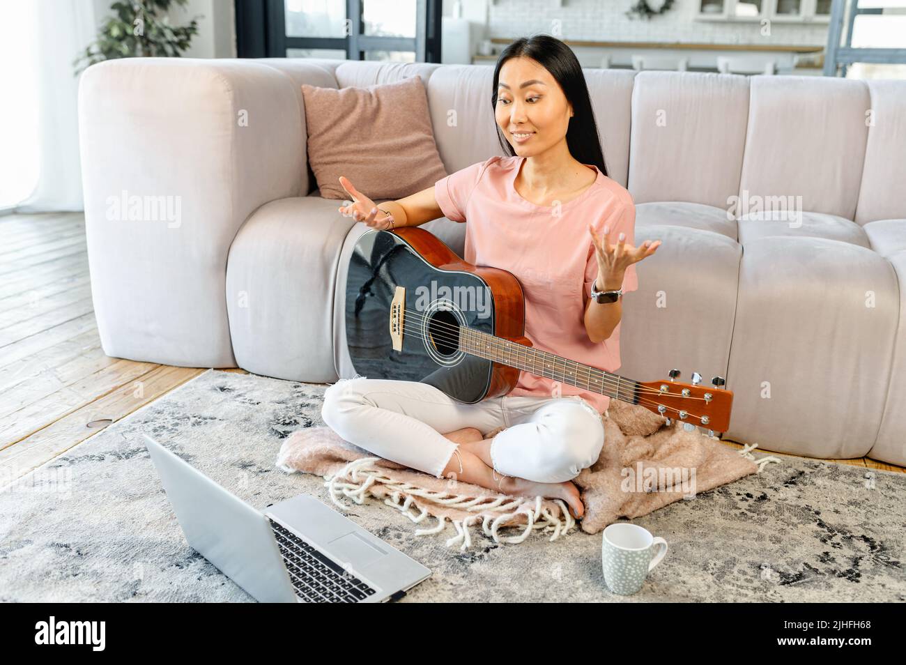 Proffesional Chinese woman sitting cross-legged on the floor with ...