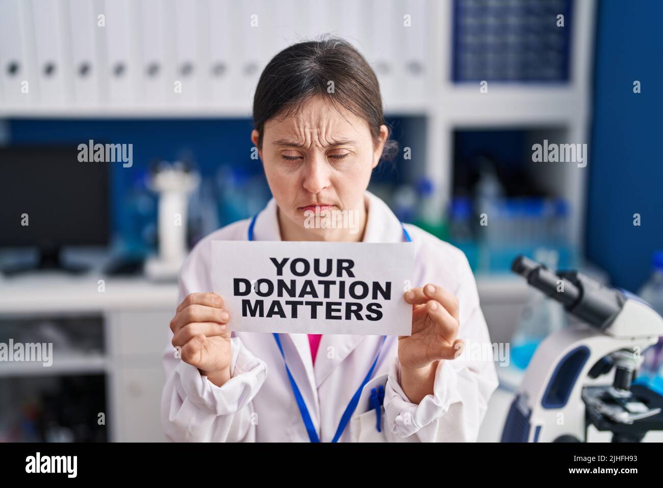 Woman with down syndrome working at scientist laboratory holding your ...