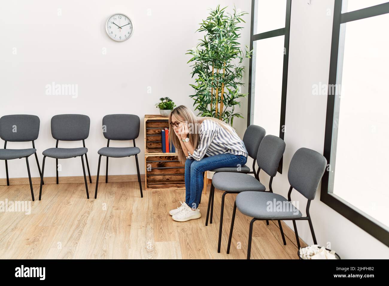 Young chinese woman desperate sitting on chair at waiting room Stock ...