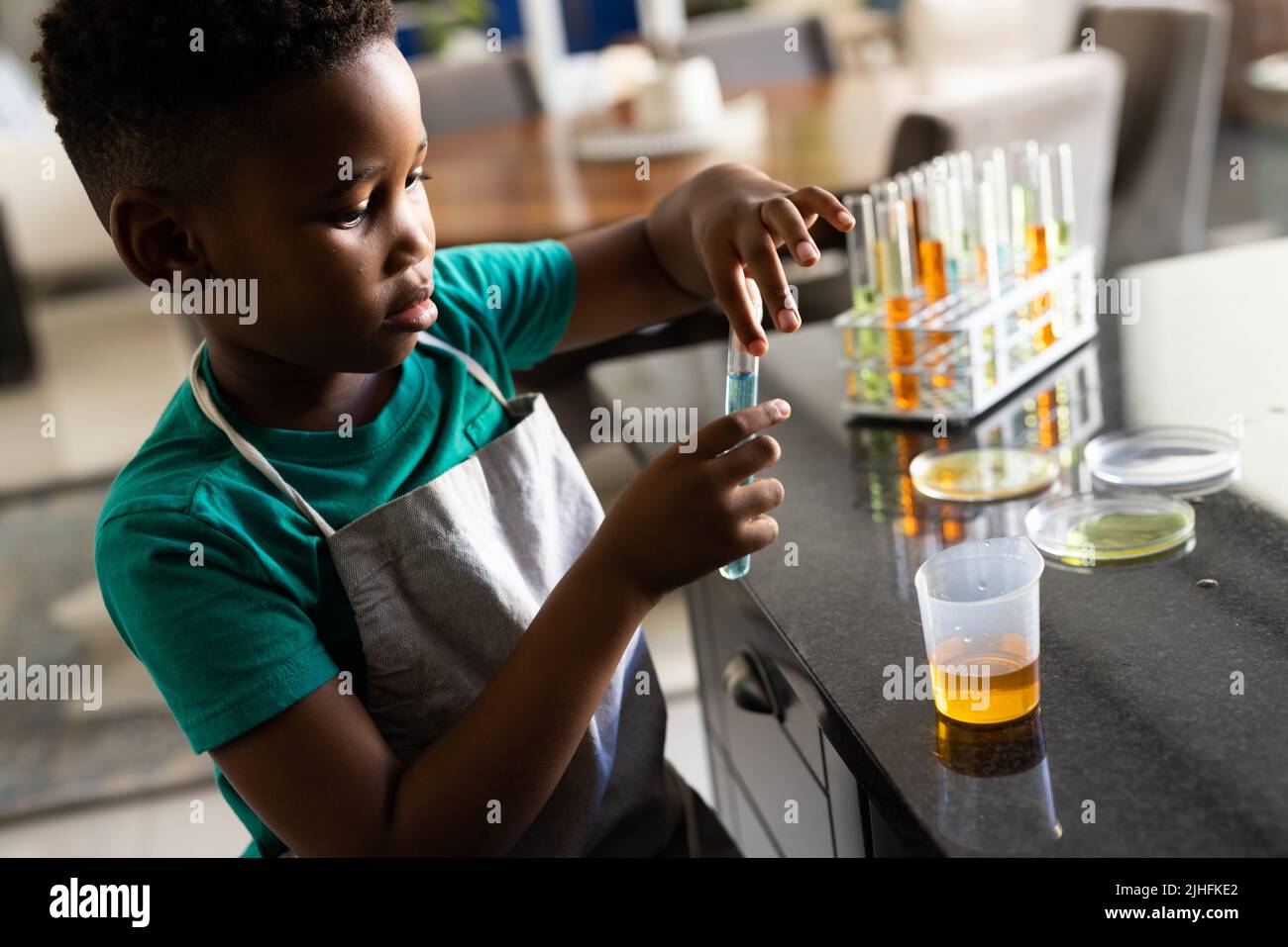 Image of smiling african american boy doing experiments at home Stock ...