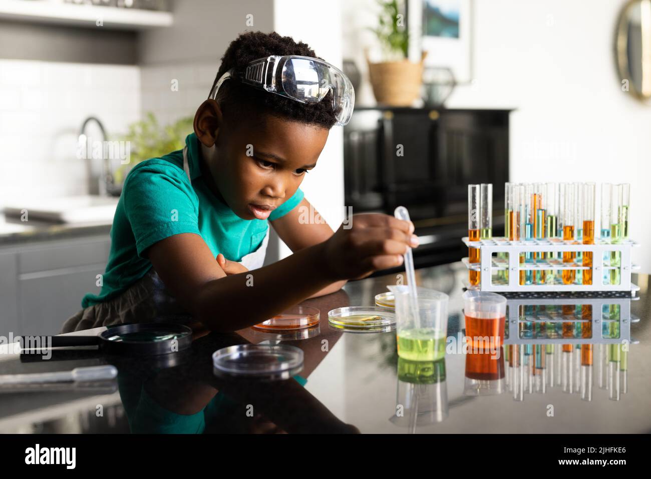 Image of smiling african american boy doing experiments at home Stock ...